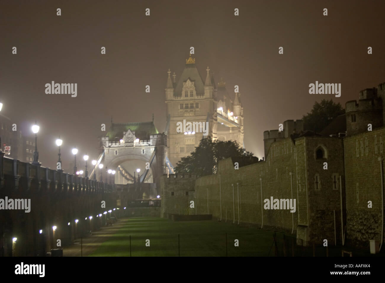 Evocative image of Tower Bridge and Tower of London at night in mist ...