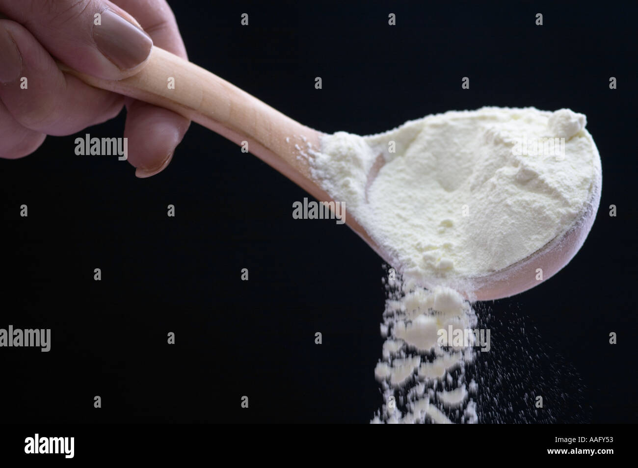 Spoonful of powdered milk being tipped out Stock Photo - Alamy