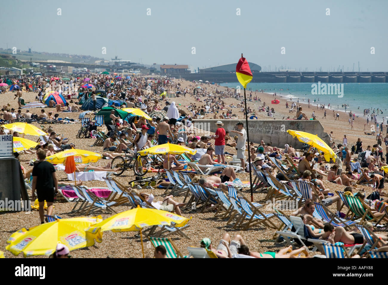 A crowded beach by the Palace Pier Brighton, Brighton Marina in far ...