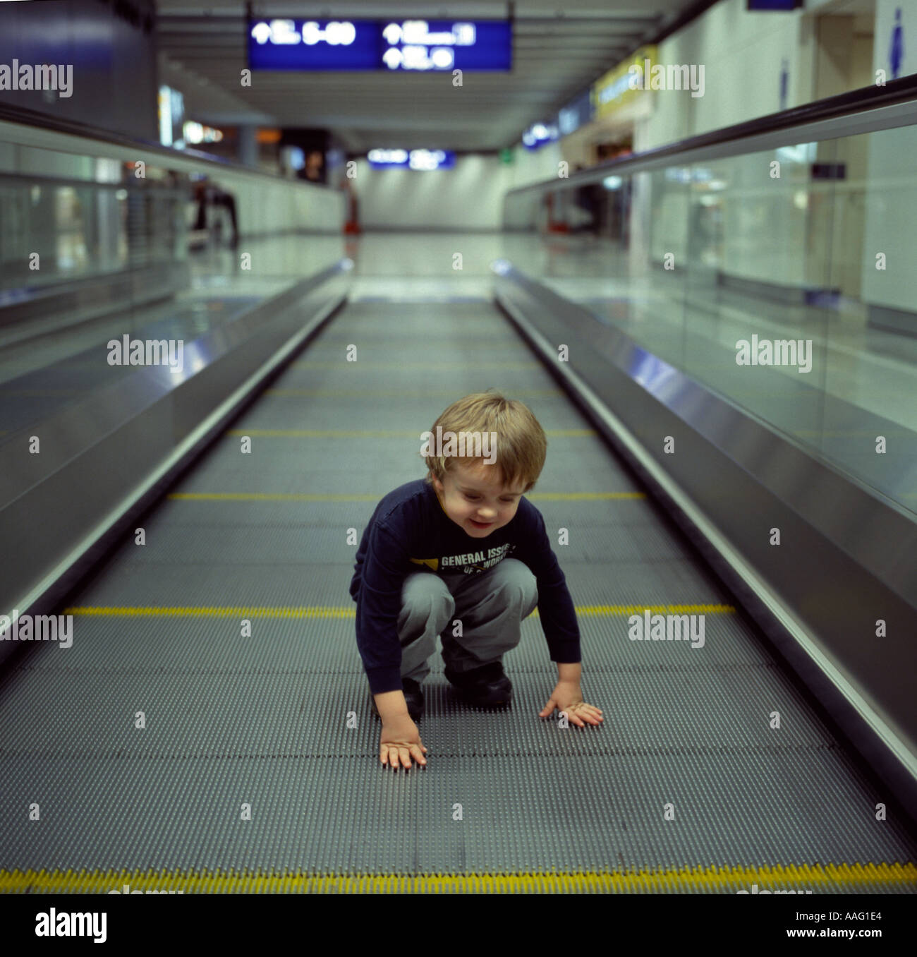 child losing balance on escalator at airport Stock Photo - Alamy