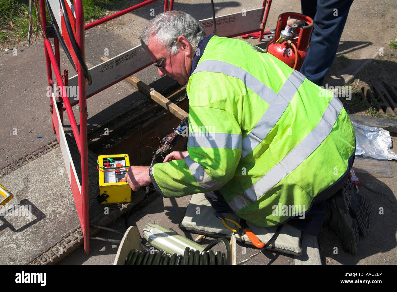 Telephone engineer carrying out roadside repairs on a faulty ...