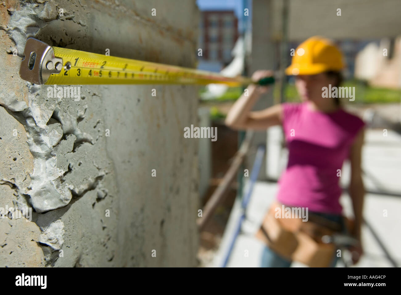 Female construction worker with measuring tape Stock Photo - Alamy