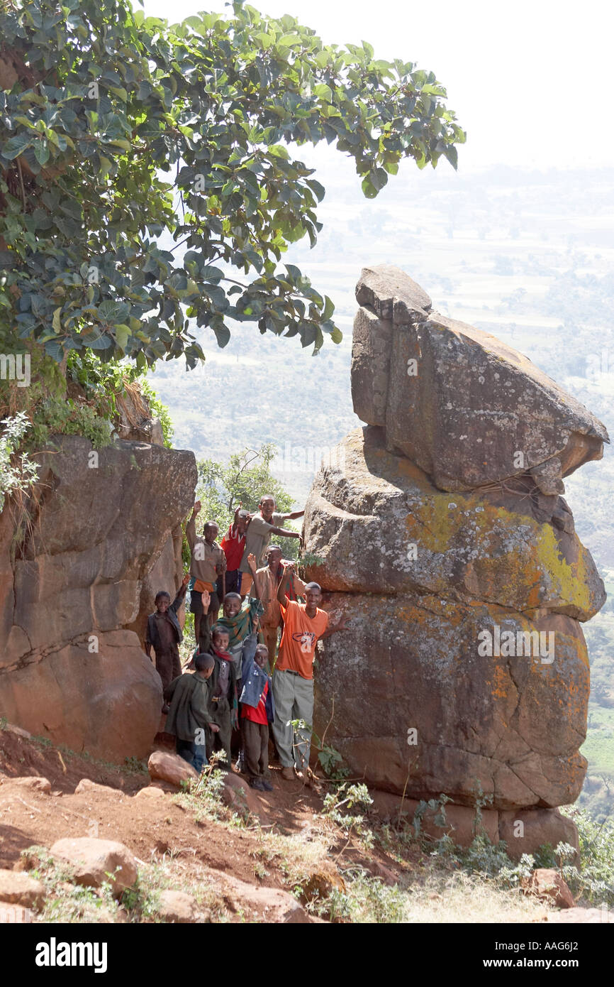 Young children playing posing standing on a stone between rocks with ...