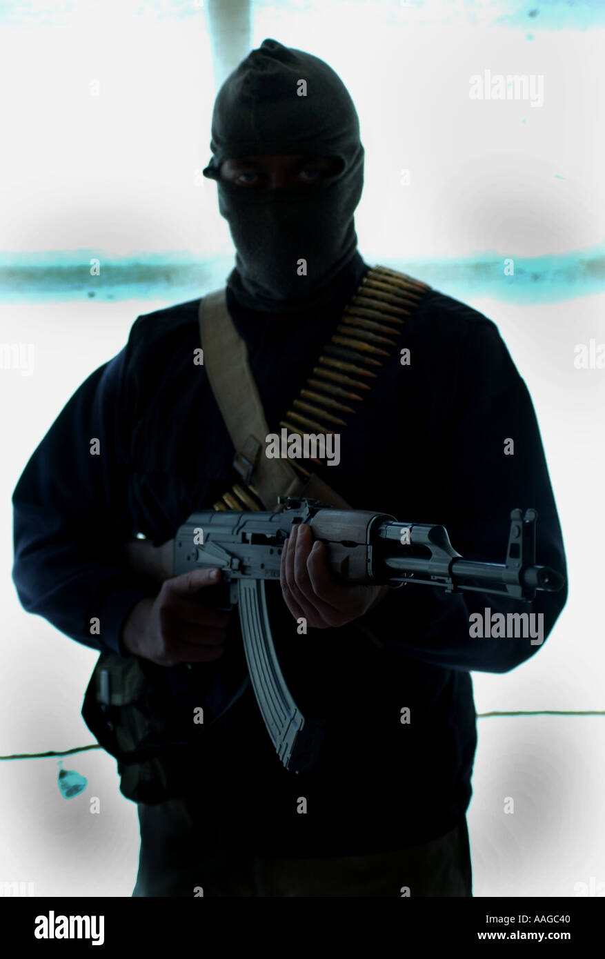 a terrorist dressed in a balaclava holding an AK47 kalashnikov rifle ...
