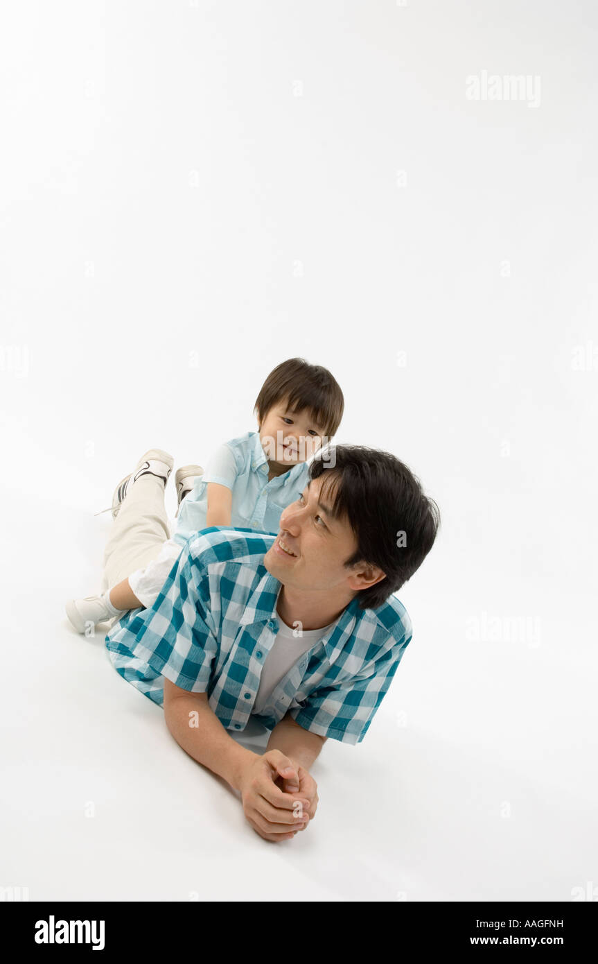 Son sitting on father s back Stock Photo - Alamy