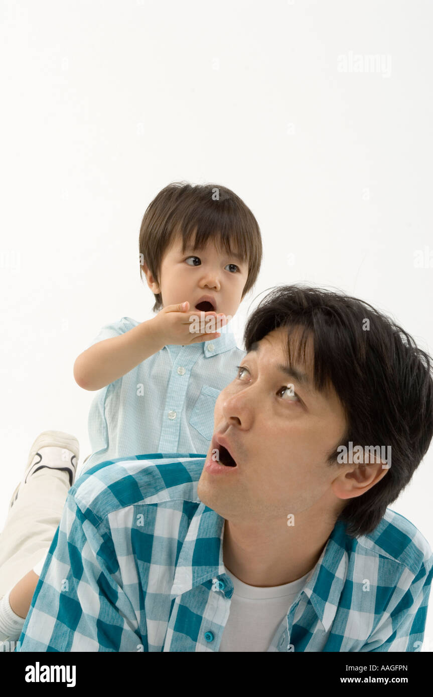 Son sitting on father s back Stock Photo - Alamy