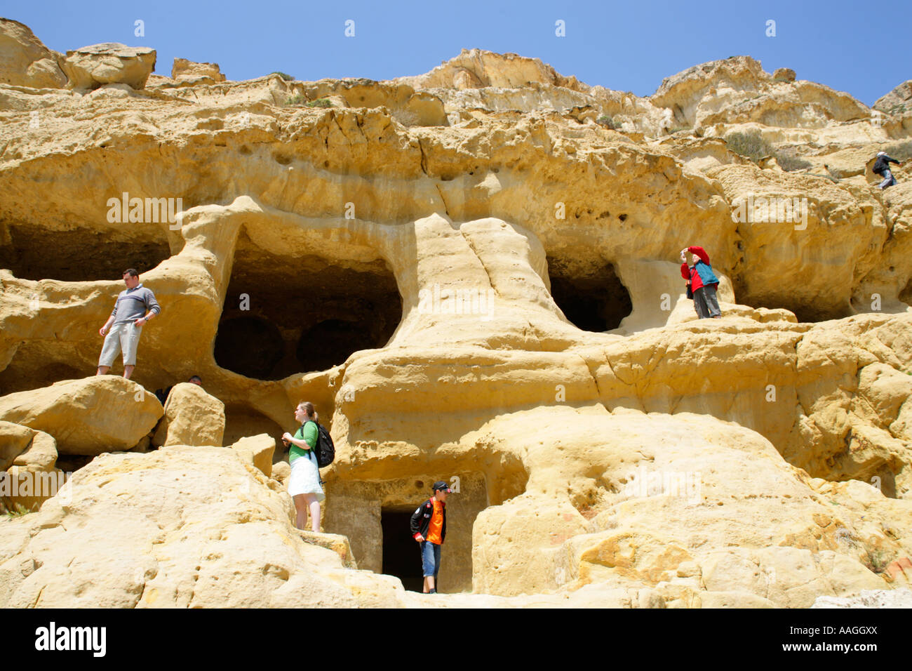 visitors at the limestone caves near Matala on the Greek Island of ...