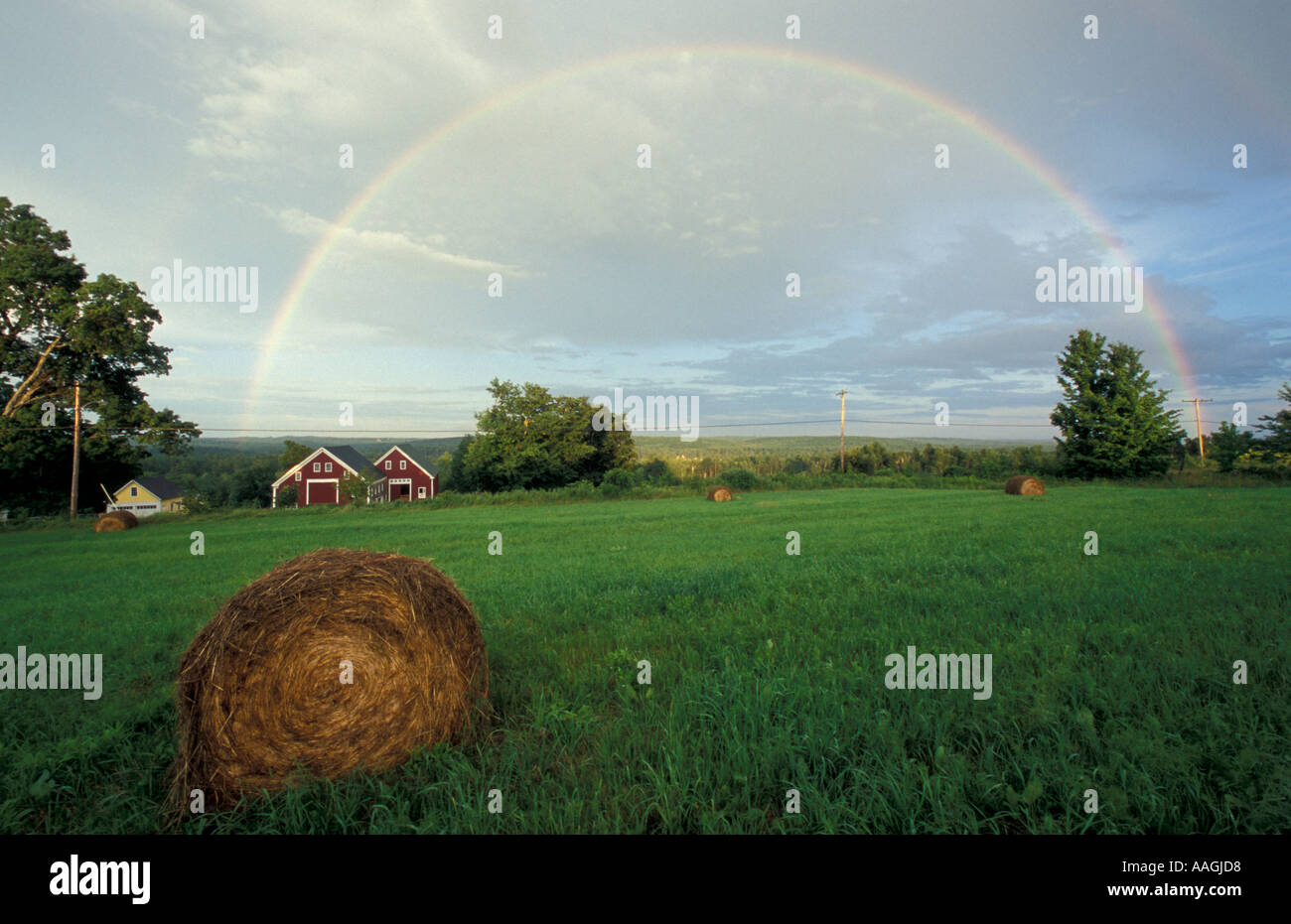Rainbow arcing over farm field with hay bale Stock Photo - Alamy