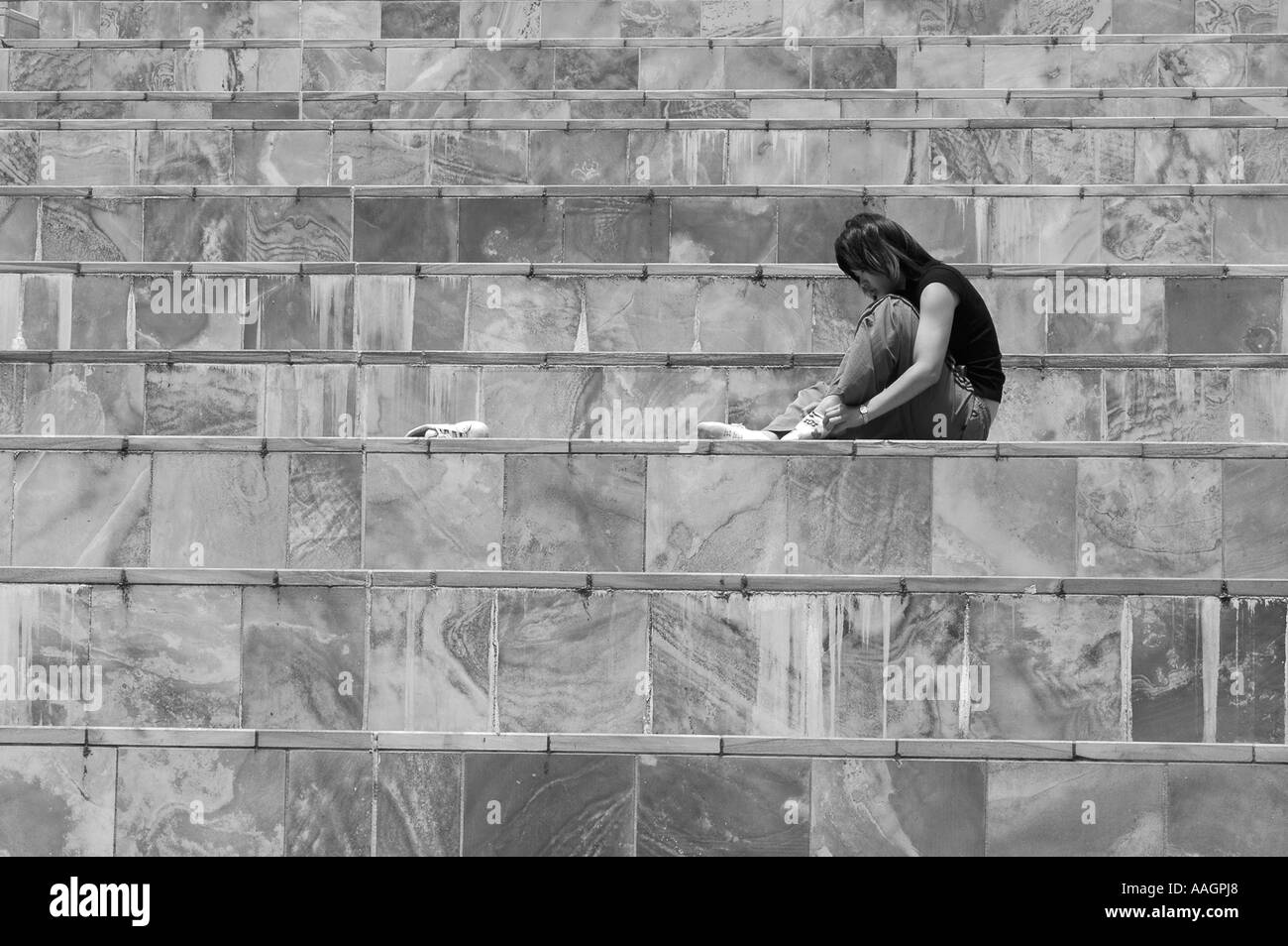 Woman sitting on steps Stock Photo - Alamy