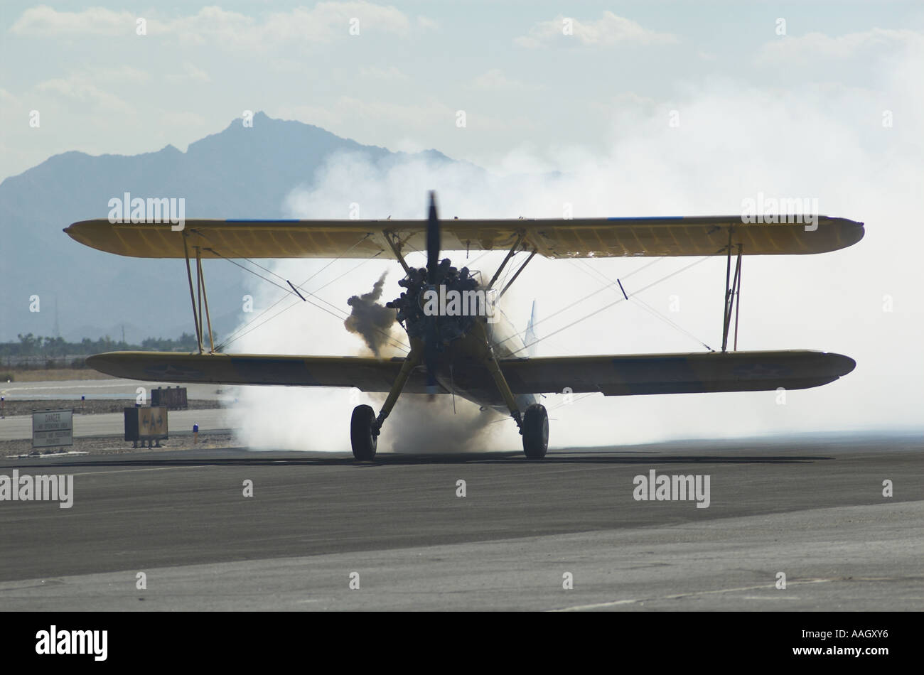 A Stearman Biplane Taxiing on Runway with Smoke Stock Photo - Alamy