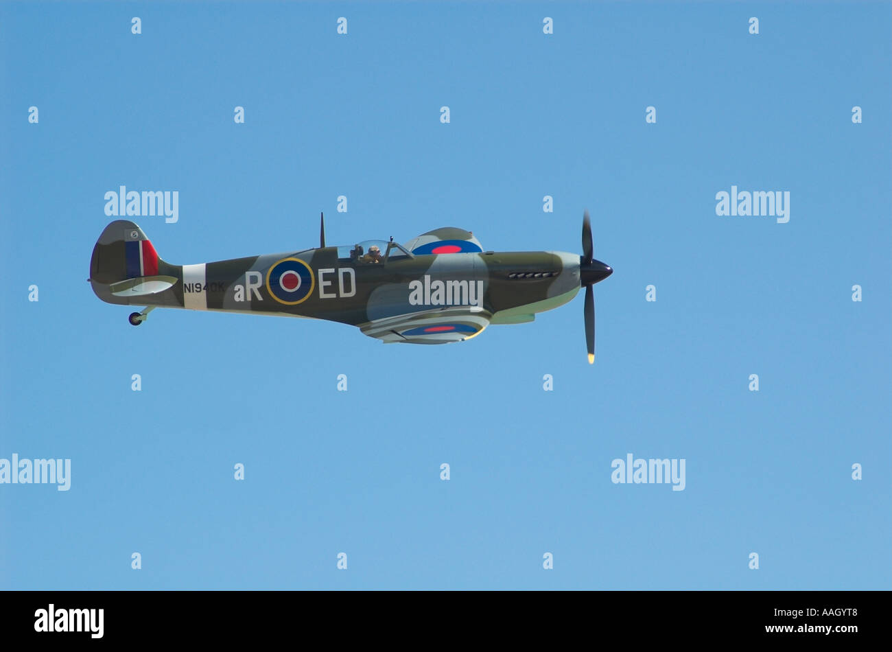 A Supermarine Spitfire flies through a blue sky Stock Photo - Alamy