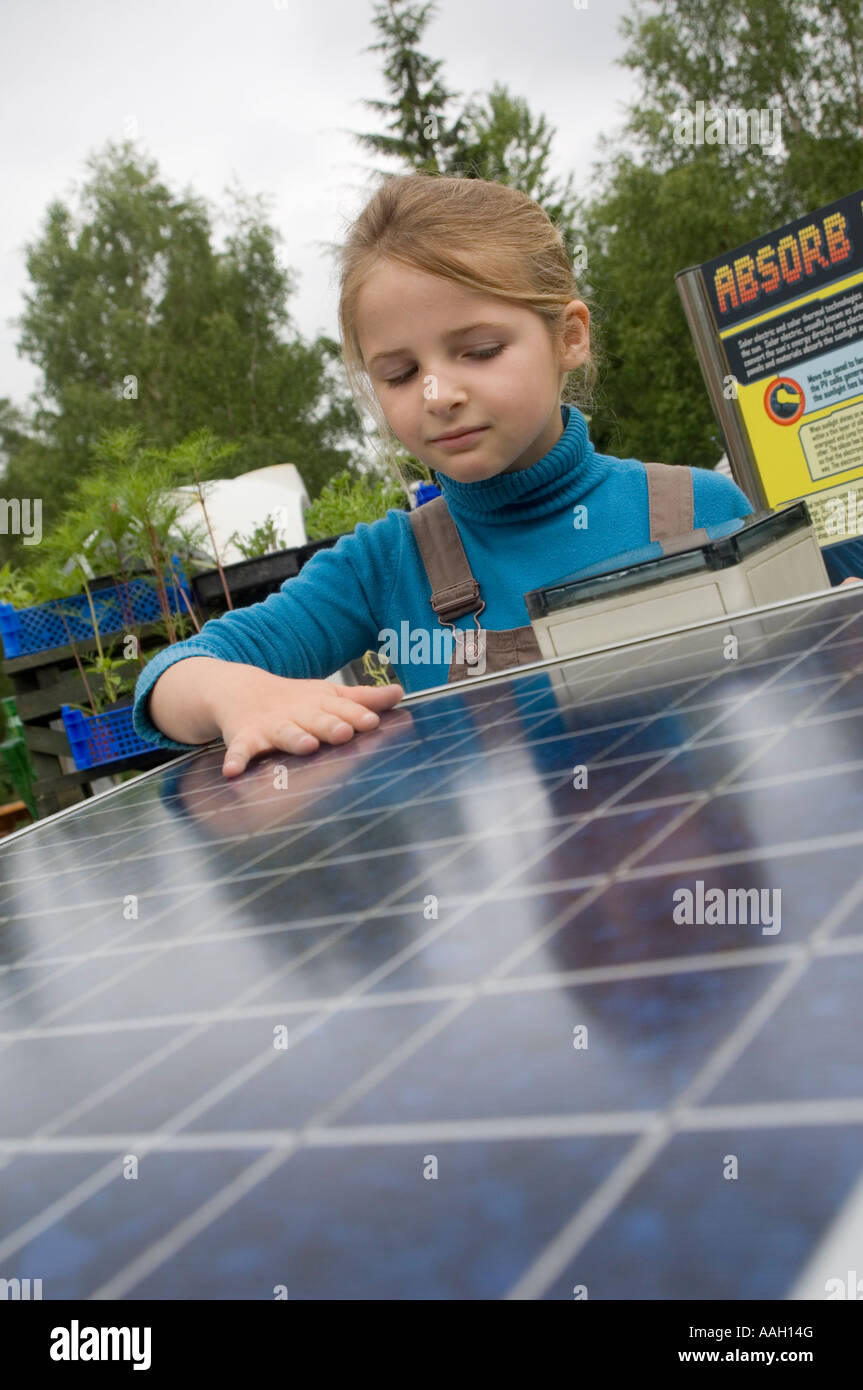 Young child touching heat absorbing display making electricty from ...