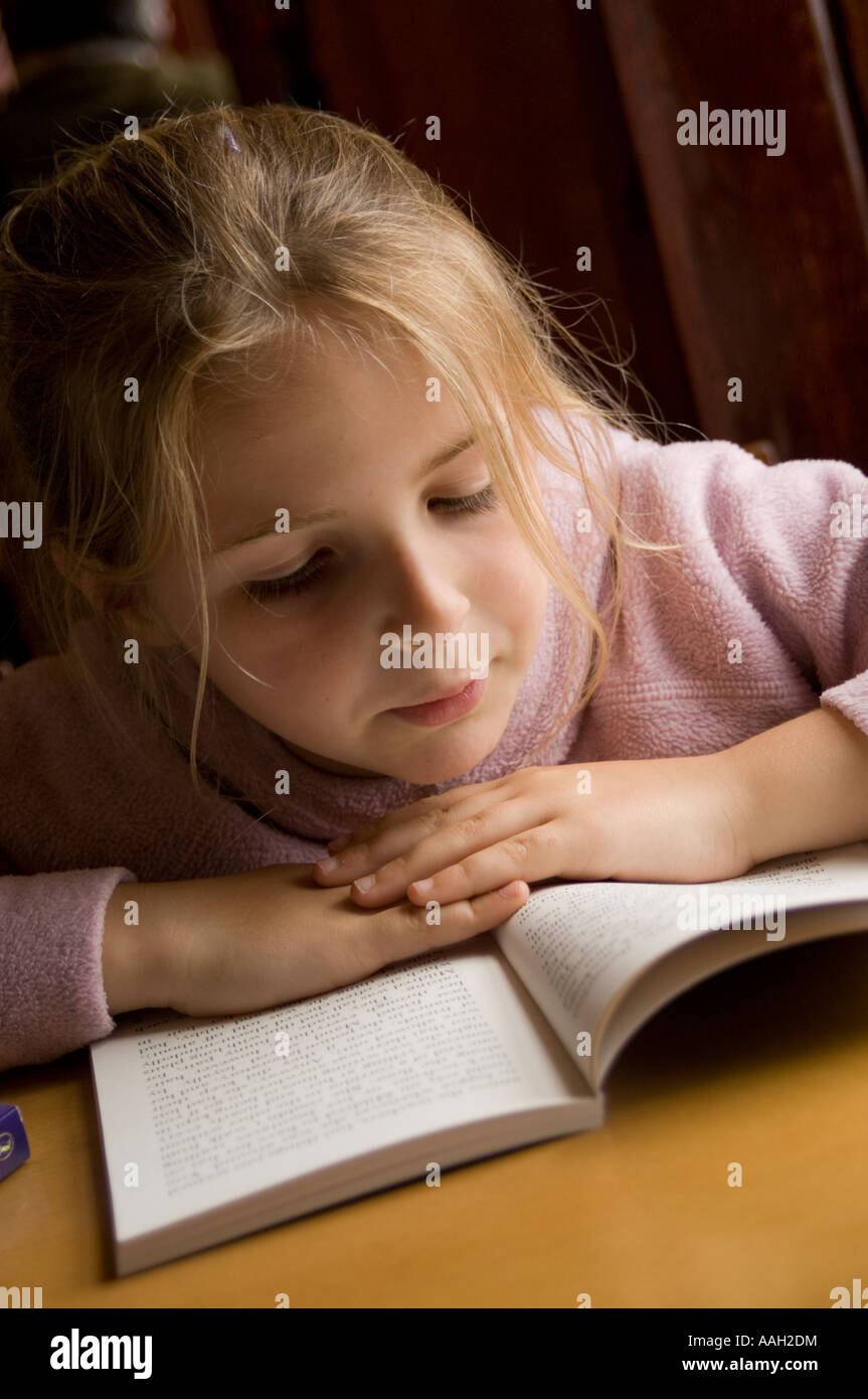 eight year old girl reading novel - concentrating on the words she is ...