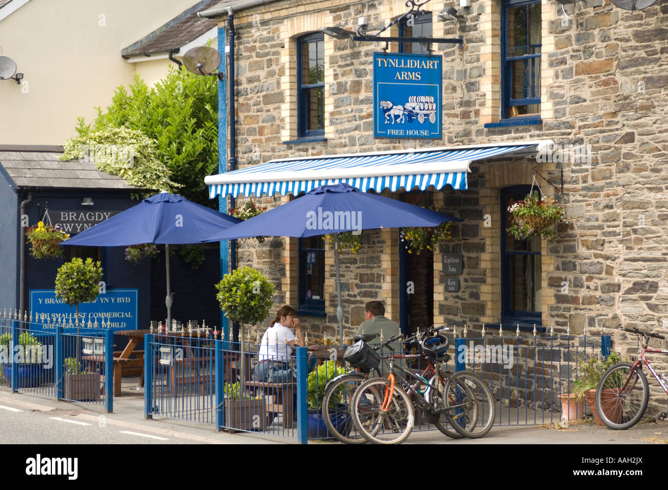 Two people sitting outside The Tynllidiart arms gastro pub bar inn ...