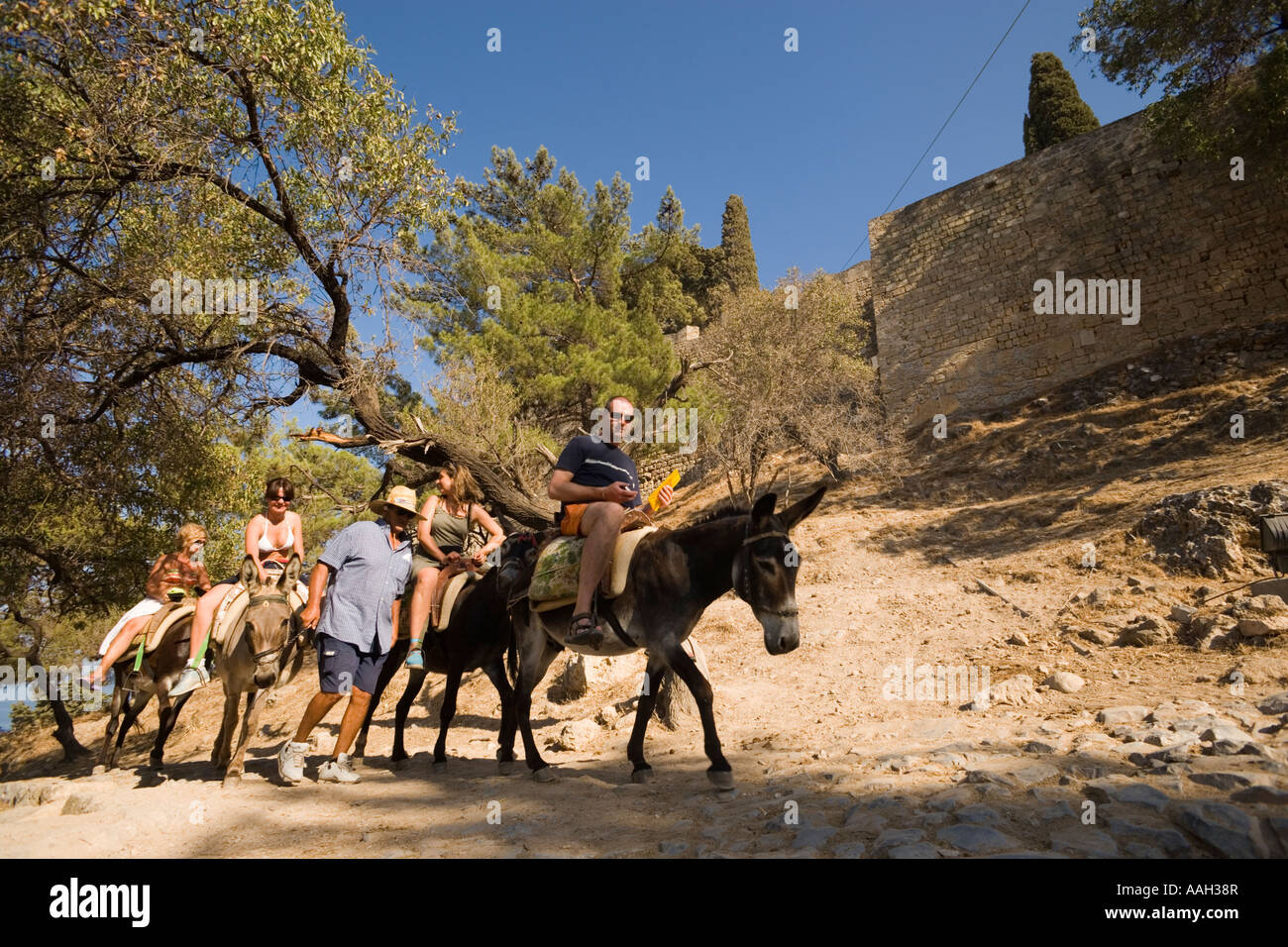 Tourists riding on donkeys to Acropolis Lindos Rhodes Greece Stock ...