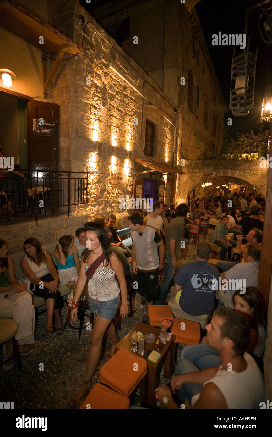 People sitting in outdoor areas of several bars of old town Rhodes Town ...