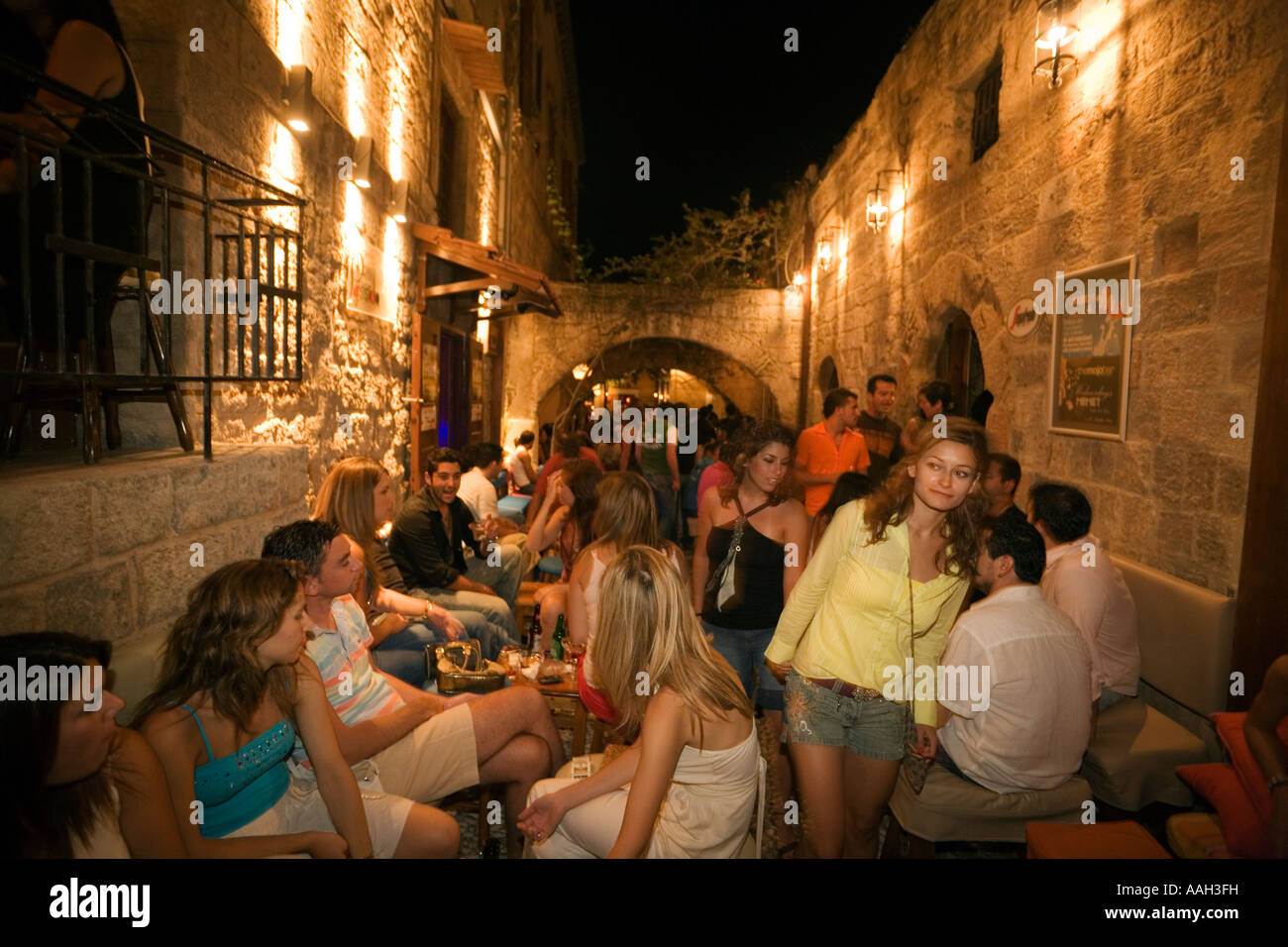 People sitting in outdoor areas of several bars of old town Rhodes Town ...
