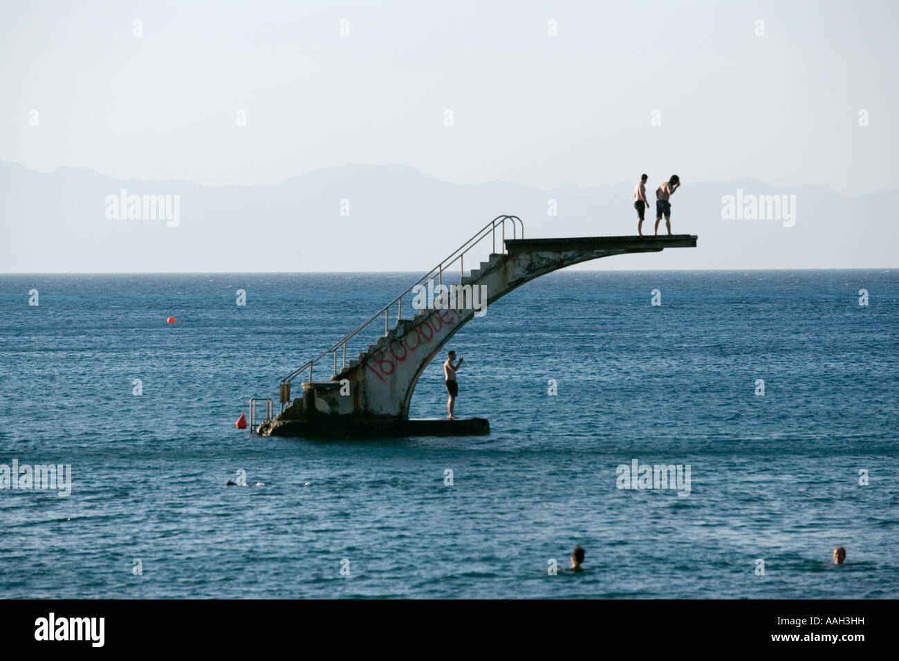 Two men standing on a diving platform at main beach Rhodes Town Rhodes ...