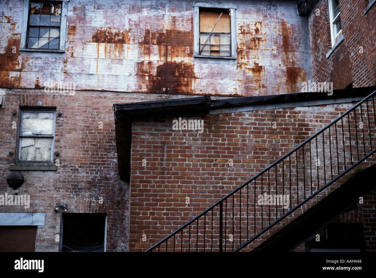 Brick wall and fire escape in a run down office building Back alley ...