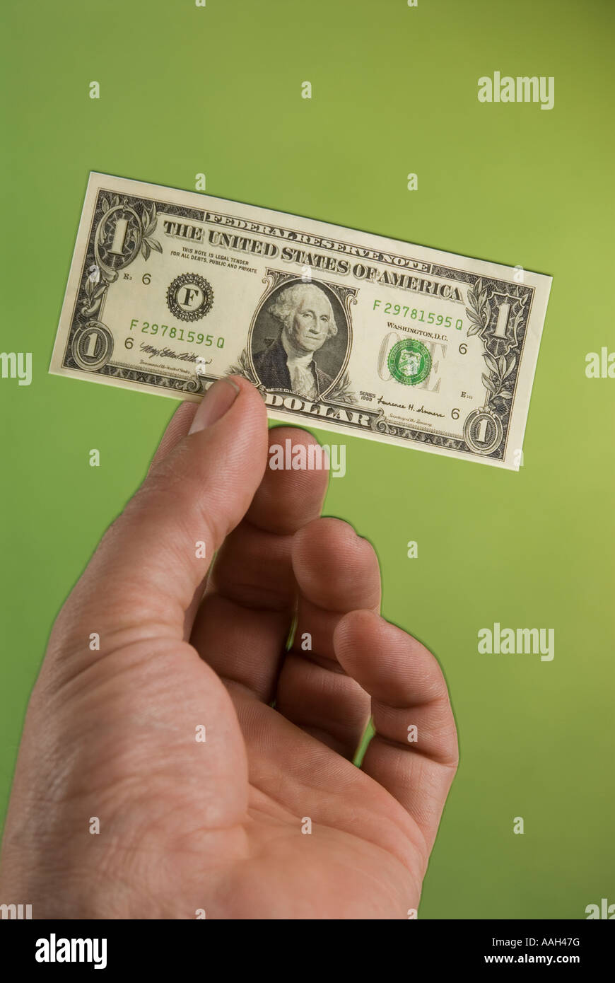 a hand holding a miniature United States one dollar bill depicting the ...