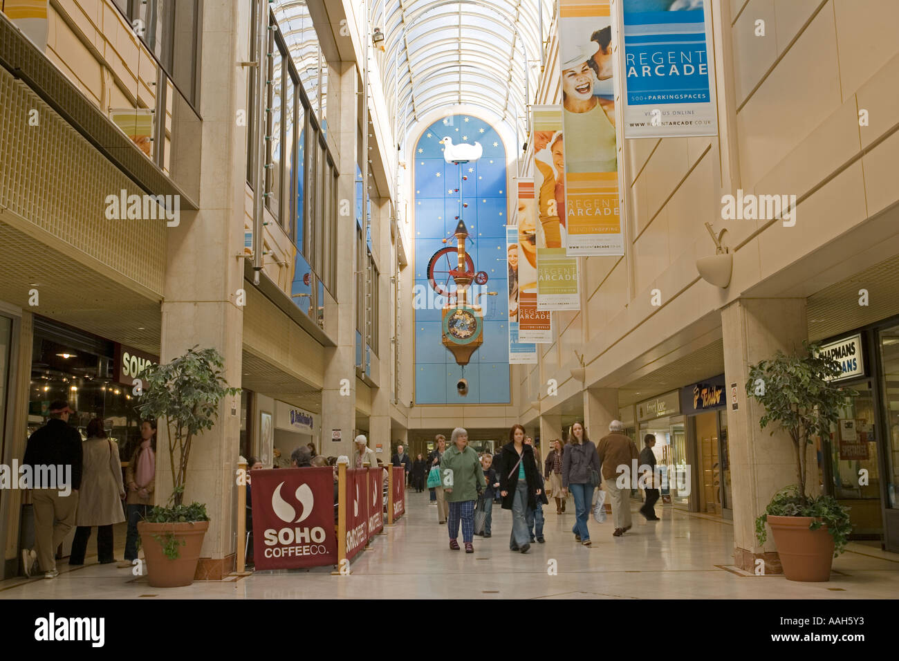 Shoppers looking at the Wishing Fish Clock Regent Arcade Cheltenham UK ...