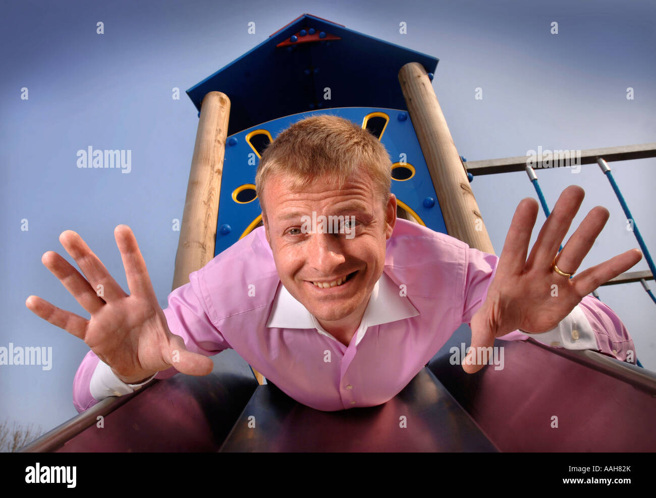 BUSINESSMAN EDWARD WEBB OF PLAYFORCE ON A SLIDE IN A PLAYGROUND NEAR ...
