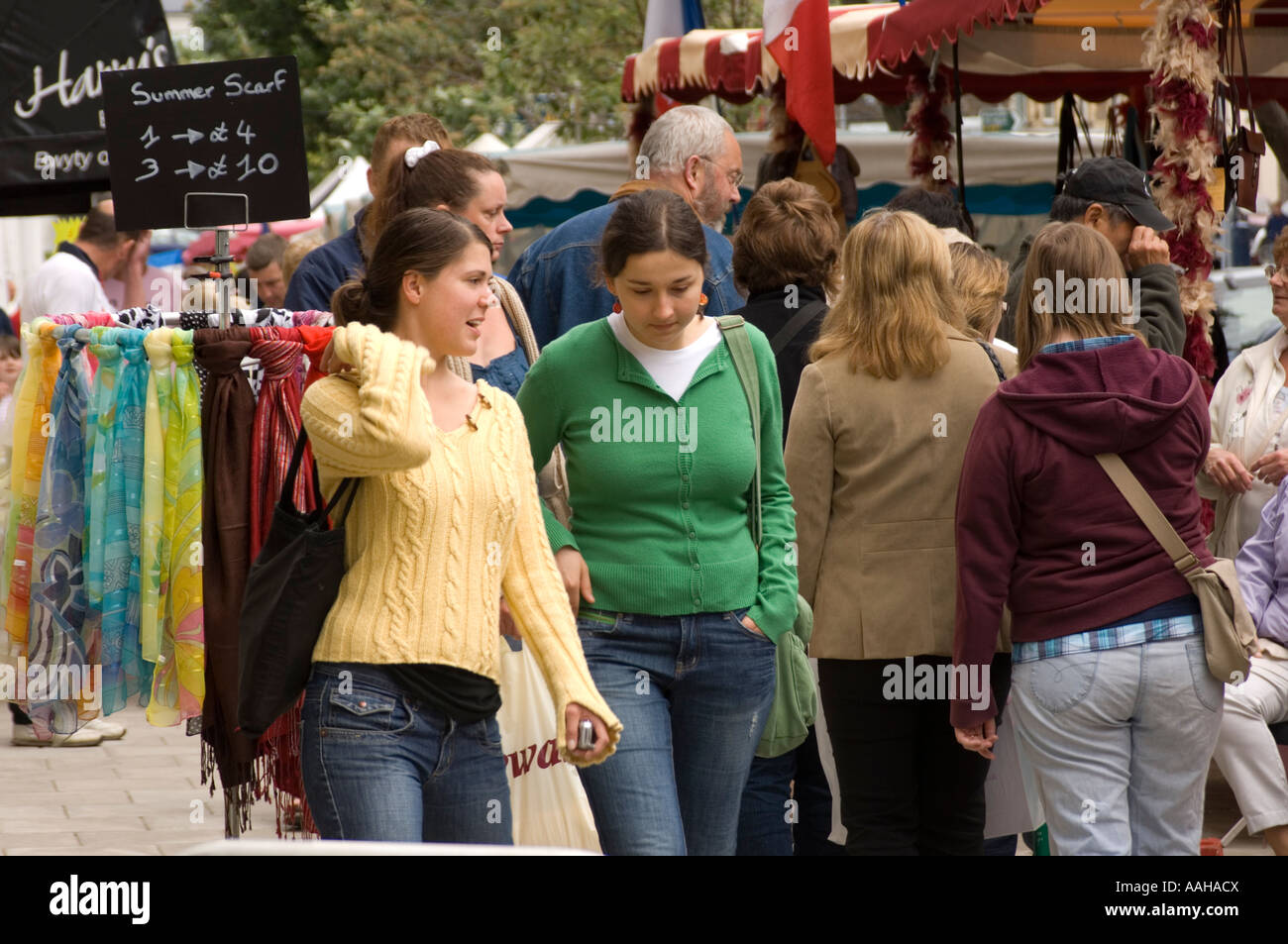 Two young Girls shopping in street market Aberystwyth Ceredigion Wales ...