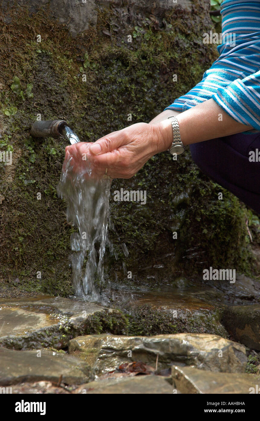 Mature woman drinking water at spring Stock Photo - Alamy