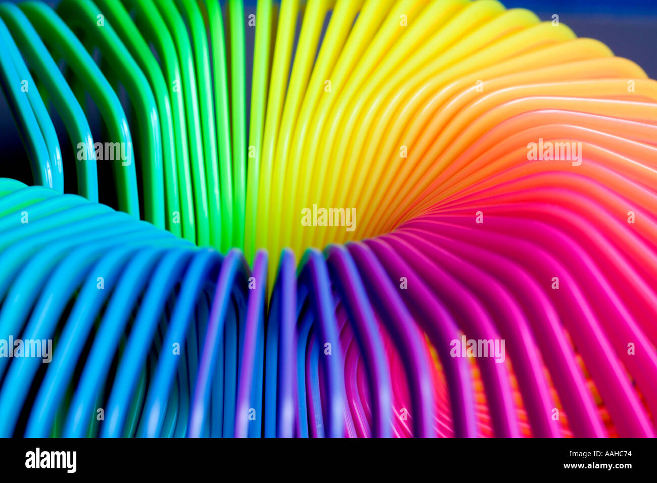 Rainbow colored plastic slinky toy Stock Photo - Alamy
