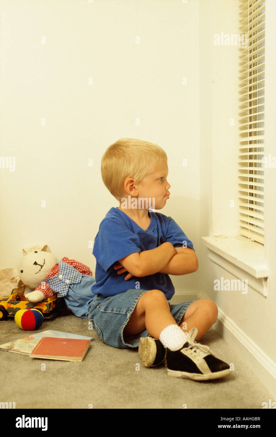 Boy 3 4 sitting with arms crossed side view Stock Photo - Alamy