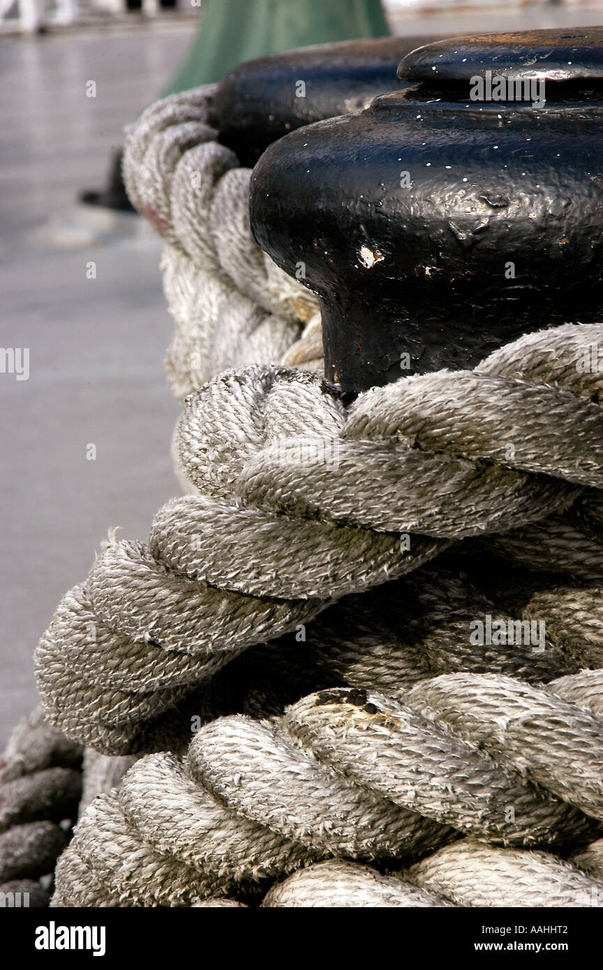 A ship secured at dock around a cleat by large weathered rope Stock ...