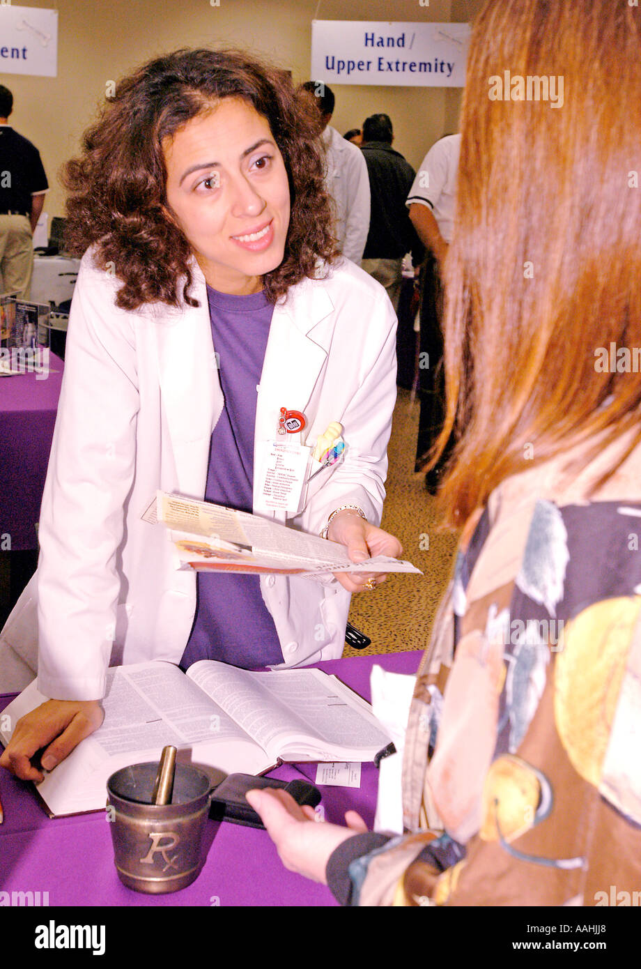 Female doctor in a white lab coat handing out Osteoporosis information ...