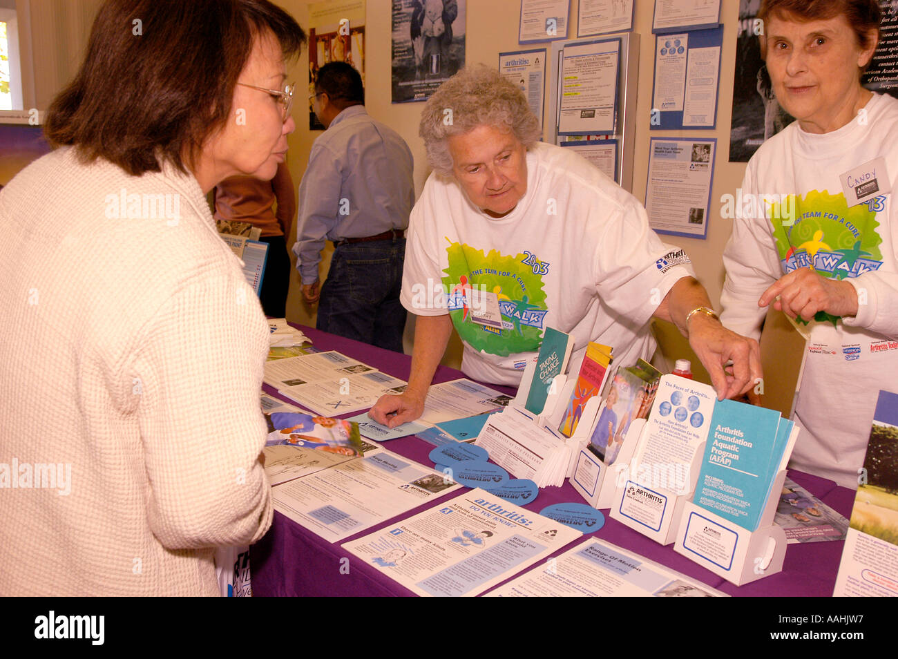 Senior elder women nursing volunteers handing out information and ...