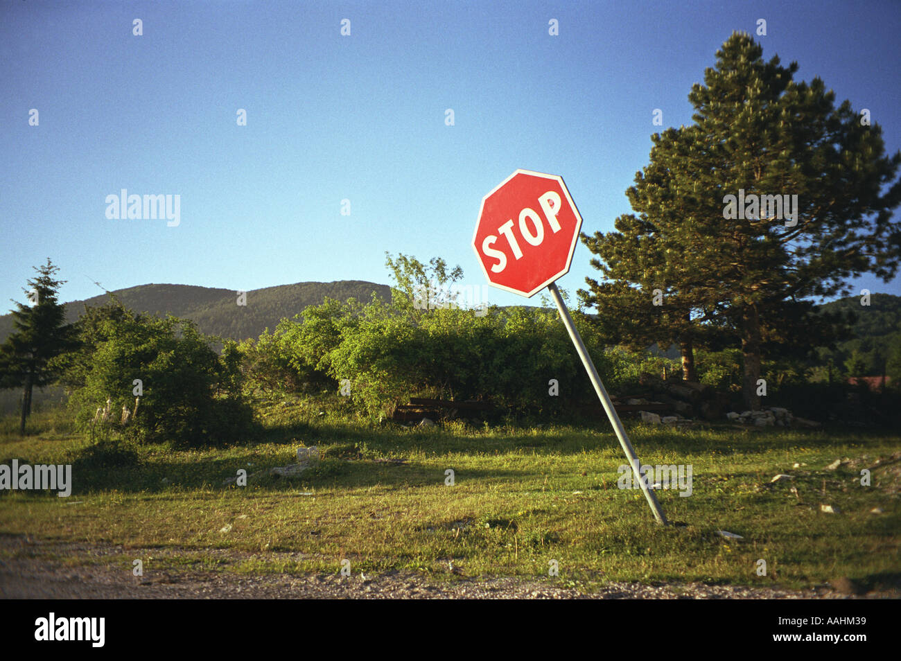 Leaning stop sign in countryside Stock Photo - Alamy