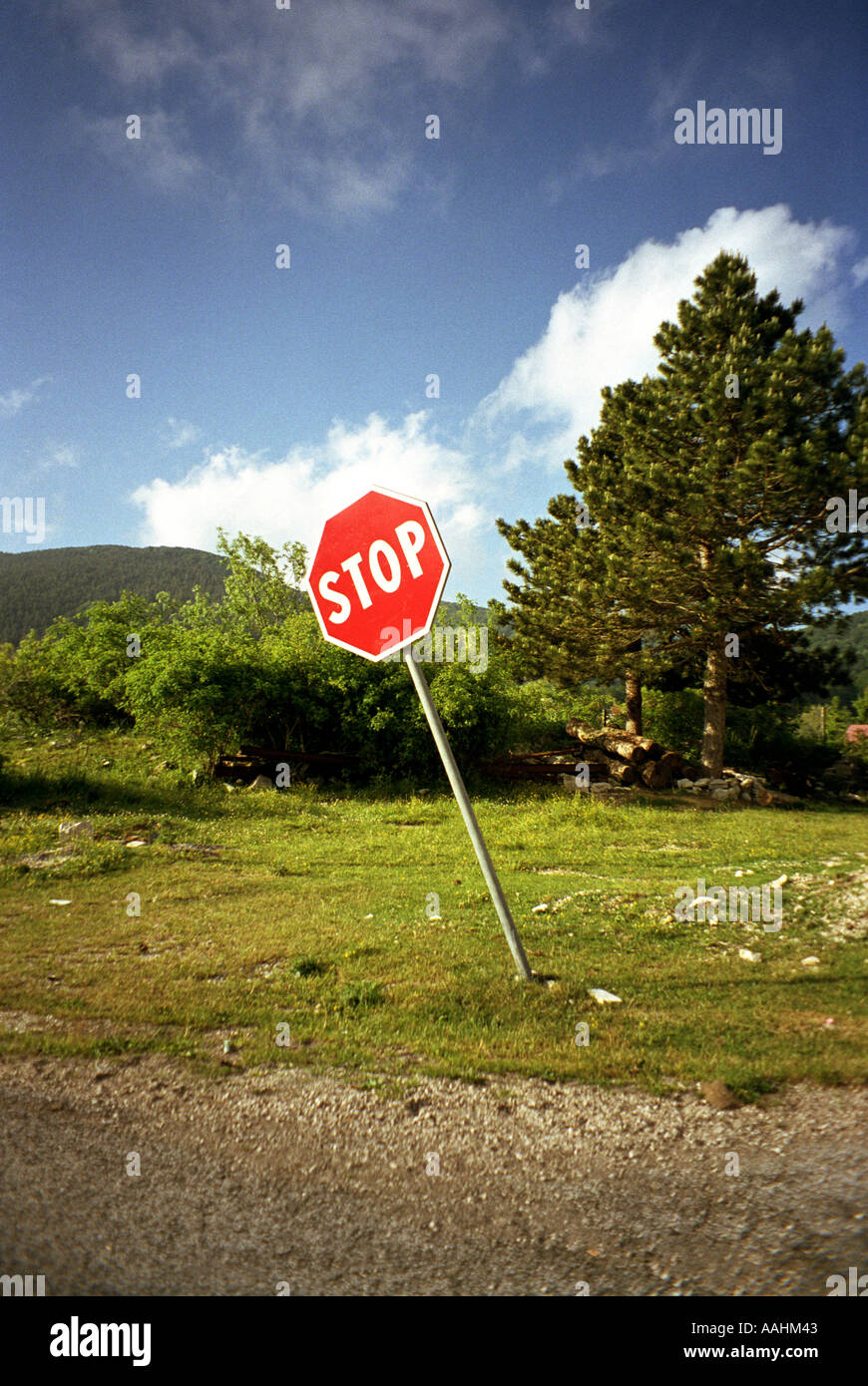 Leaning stop sign in countryside Stock Photo - Alamy