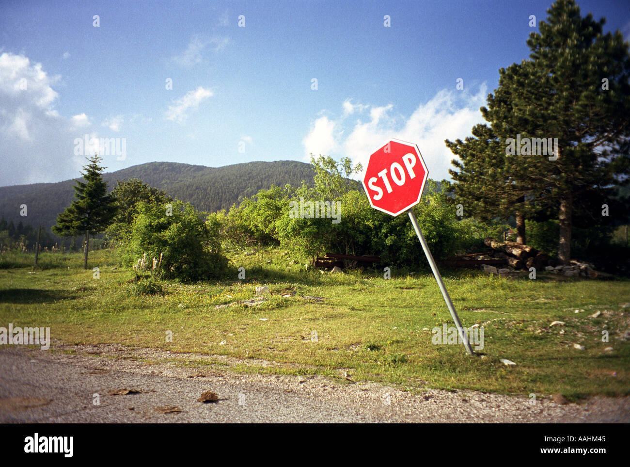 Leaning stop sign in countryside Stock Photo - Alamy