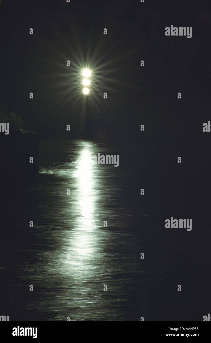 three spotlights by riverbank with reflection in river Stock Photo - Alamy