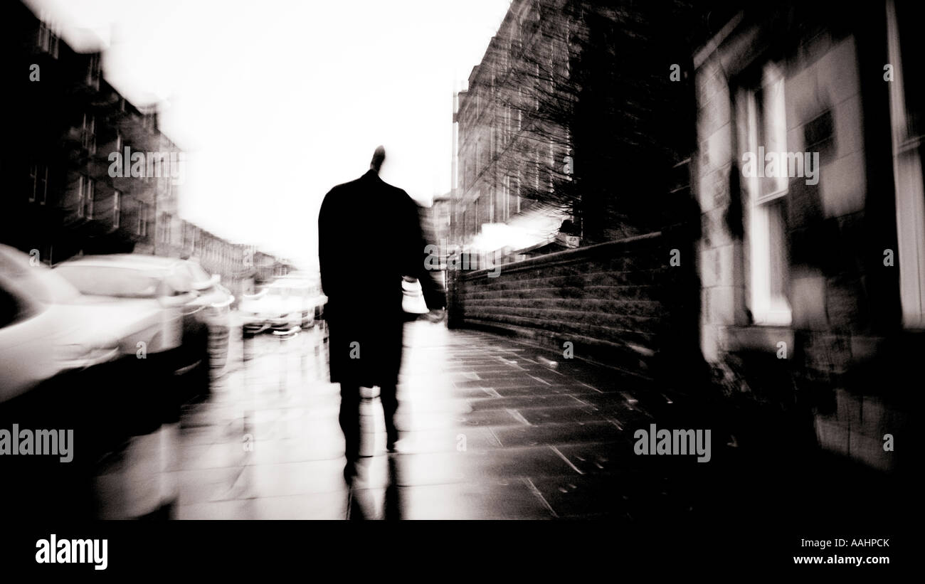 A mysterious dark figure walking down a wet road Stock Photo - Alamy