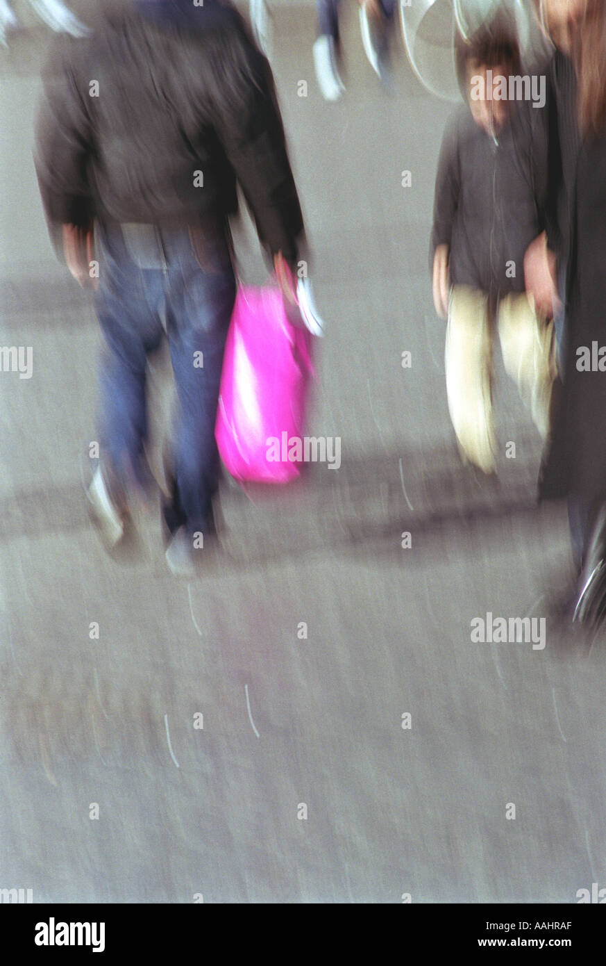 teenage man walking with pink shopping bag in crowd blurred Stock Photo ...