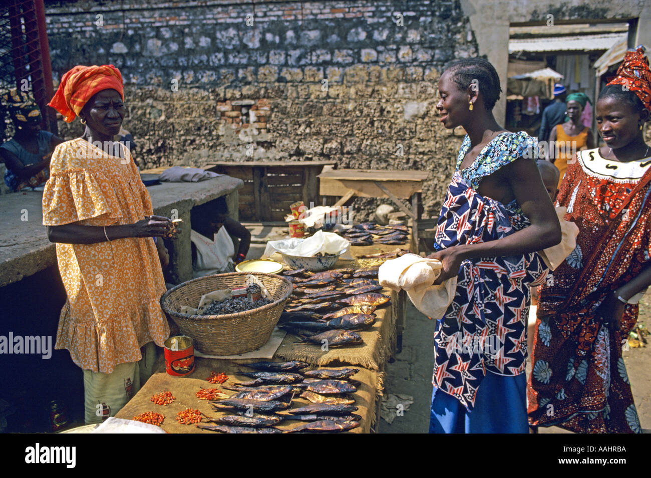 Gambian woman in colourful dress in outdoor fish market in Banjul The ...