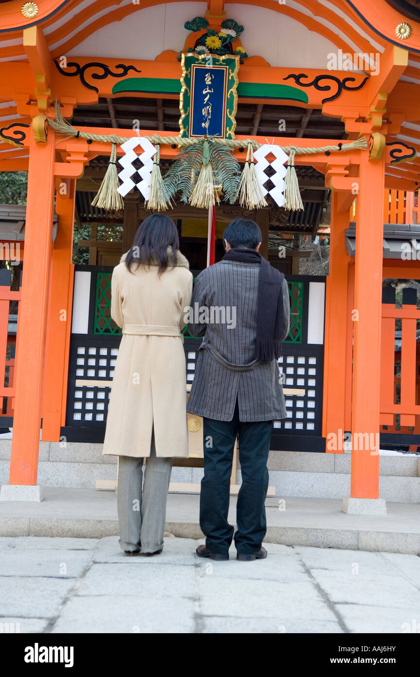 Couple praying at shrine Stock Photo - Alamy