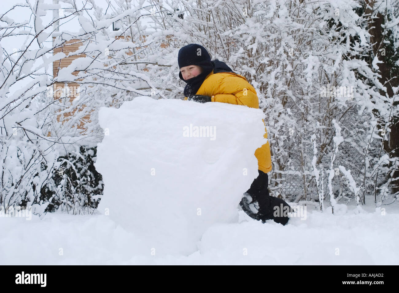 8 year old boy building a snow man MR Stock Photo - Alamy