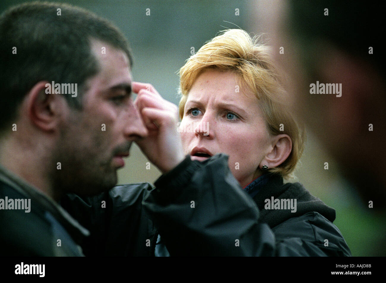 Female trainer attends to a rugby player injury during a match at ...