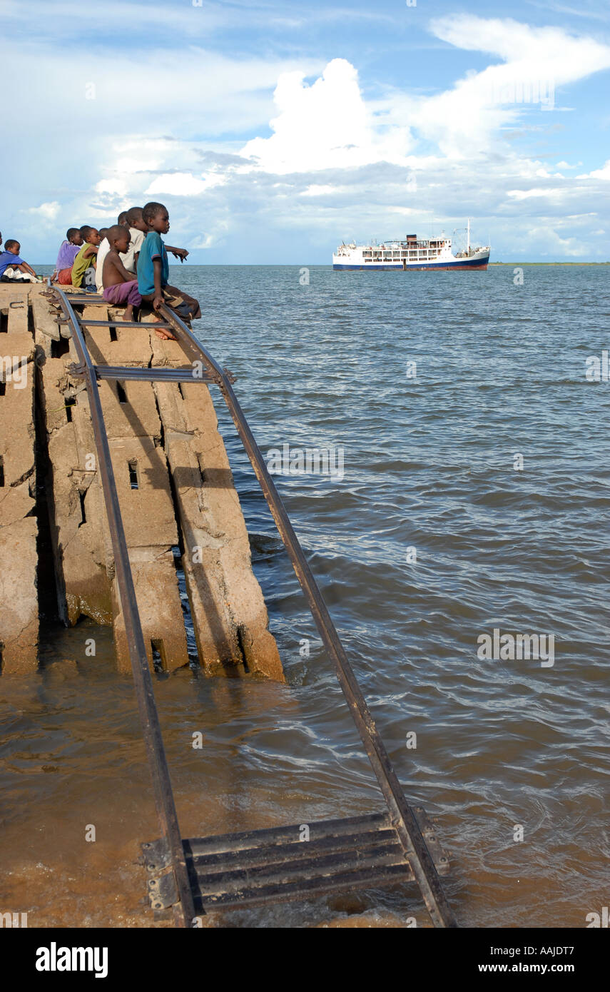 kids on broken rail pontoon watching the Ilala on Lake Malawi, Africa ...