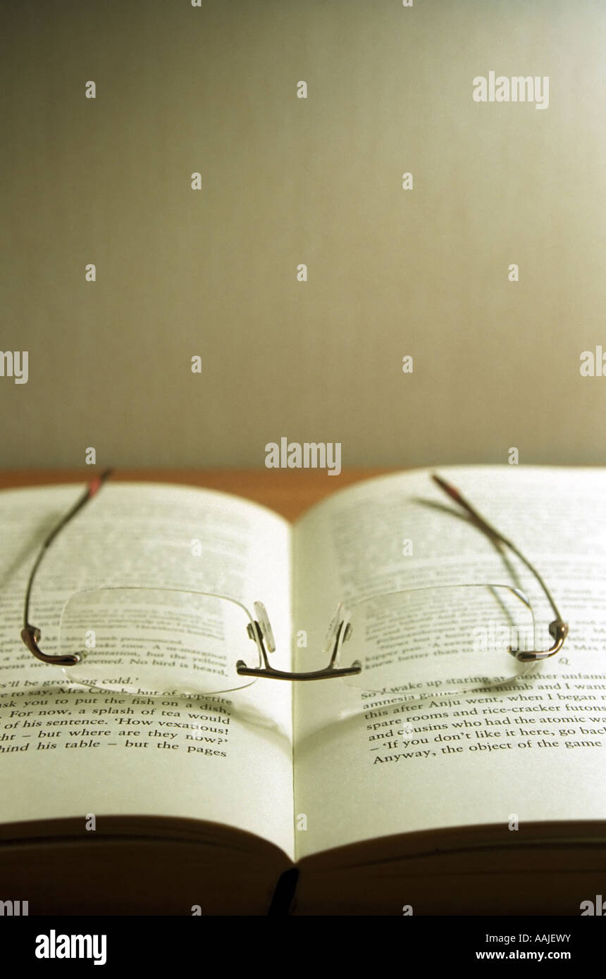 A pair of rimless spectacles lying on an open book Stock Photo - Alamy
