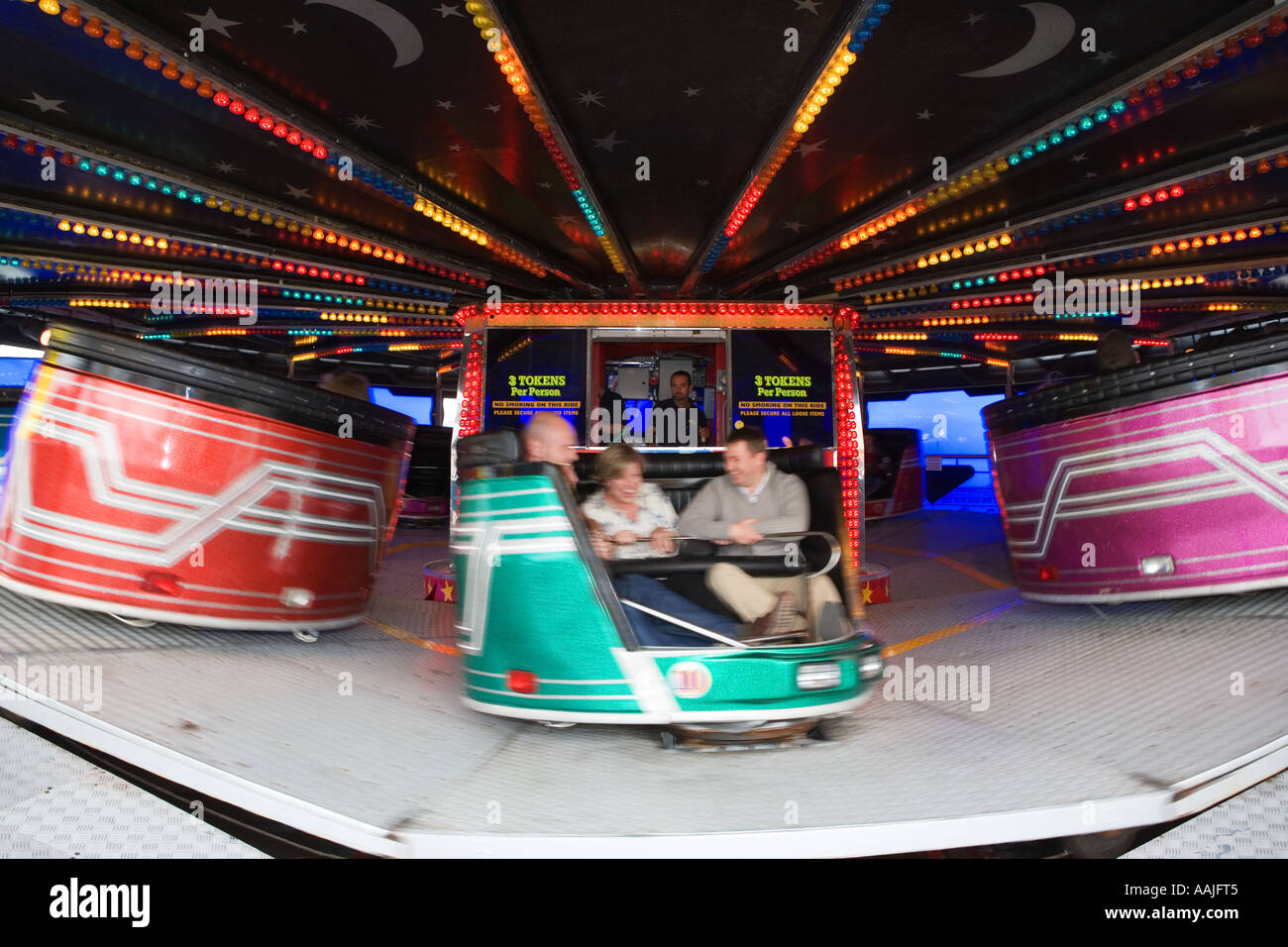 Three people on a Waltzer fairground ride Stock Photo - Alamy