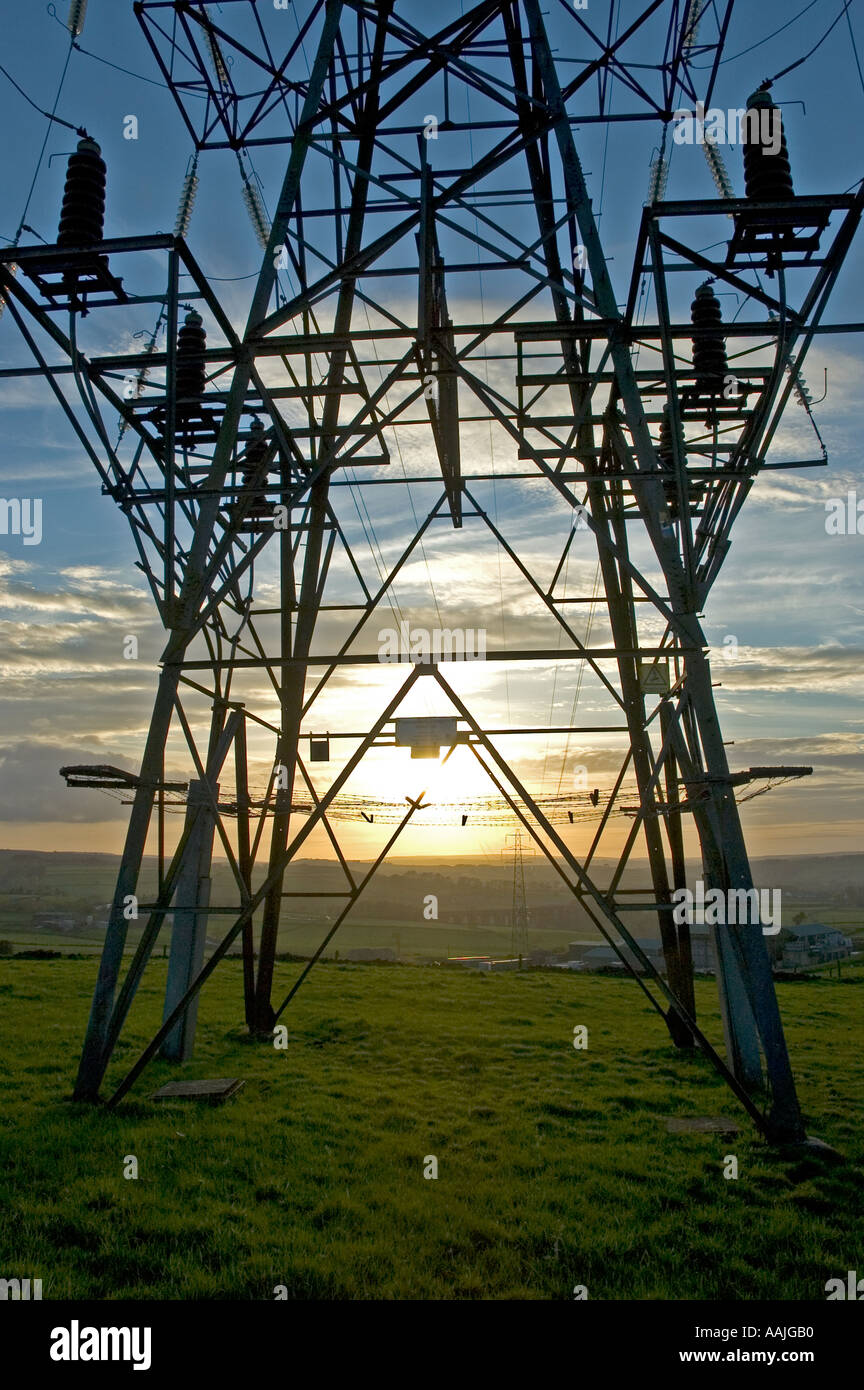 Sun setting behind electricity pylon Stock Photo - Alamy