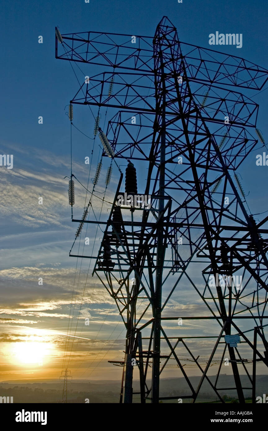 Sun setting behind electricity pylon Stock Photo - Alamy