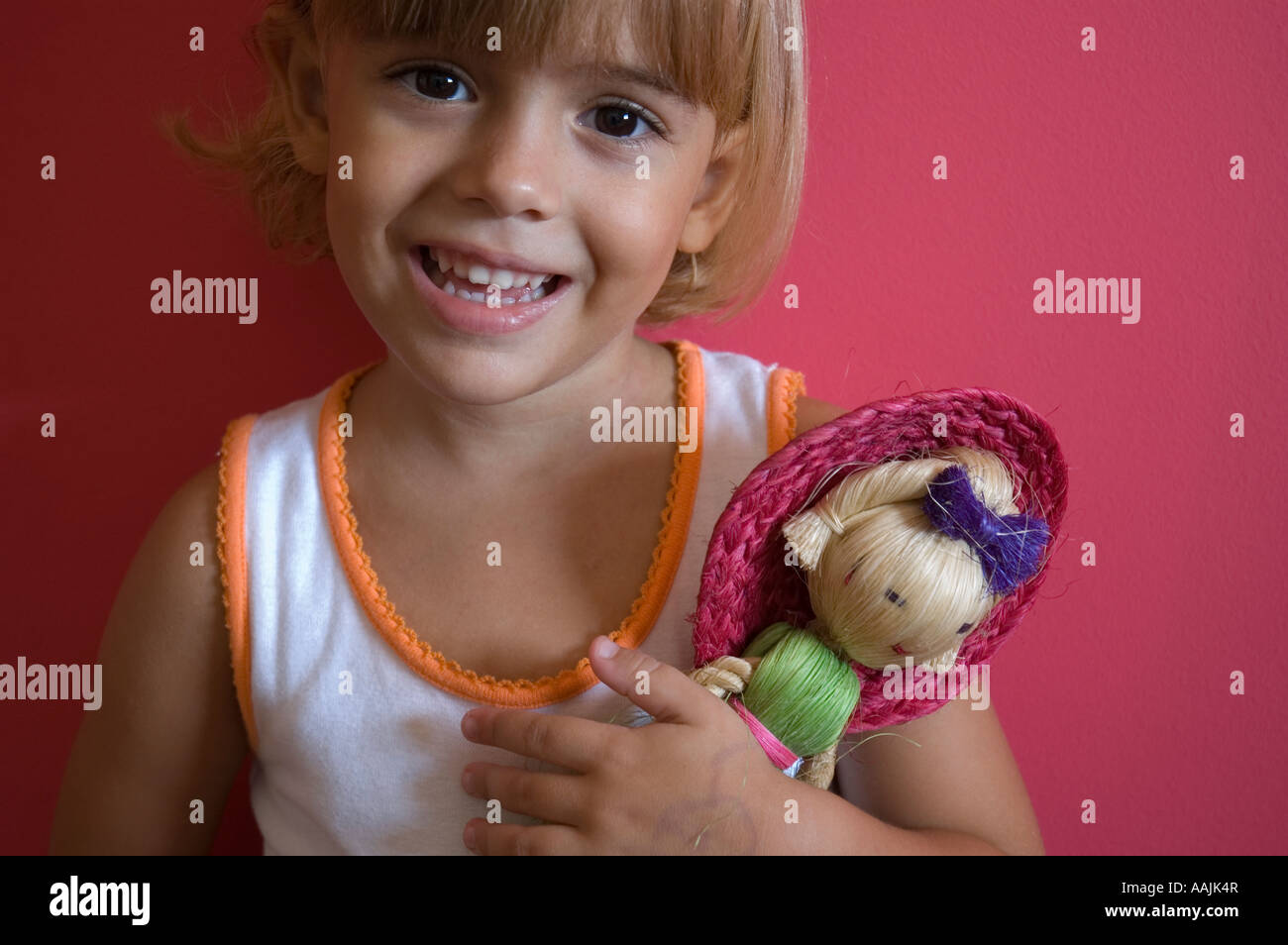 Portrait of a girl holding a doll and smiling Stock Photo - Alamy