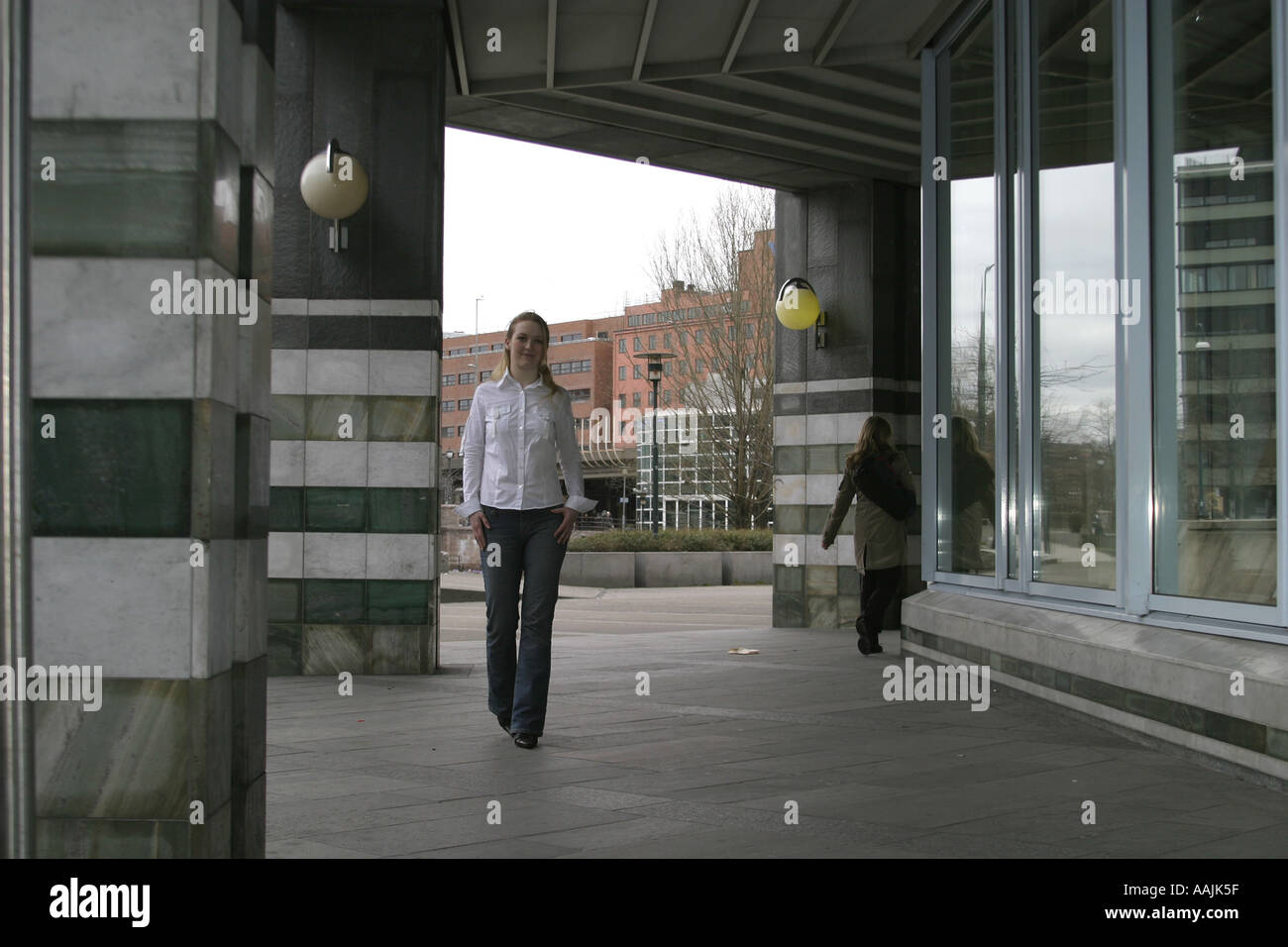 Young woman walking in a corridor Stock Photo - Alamy